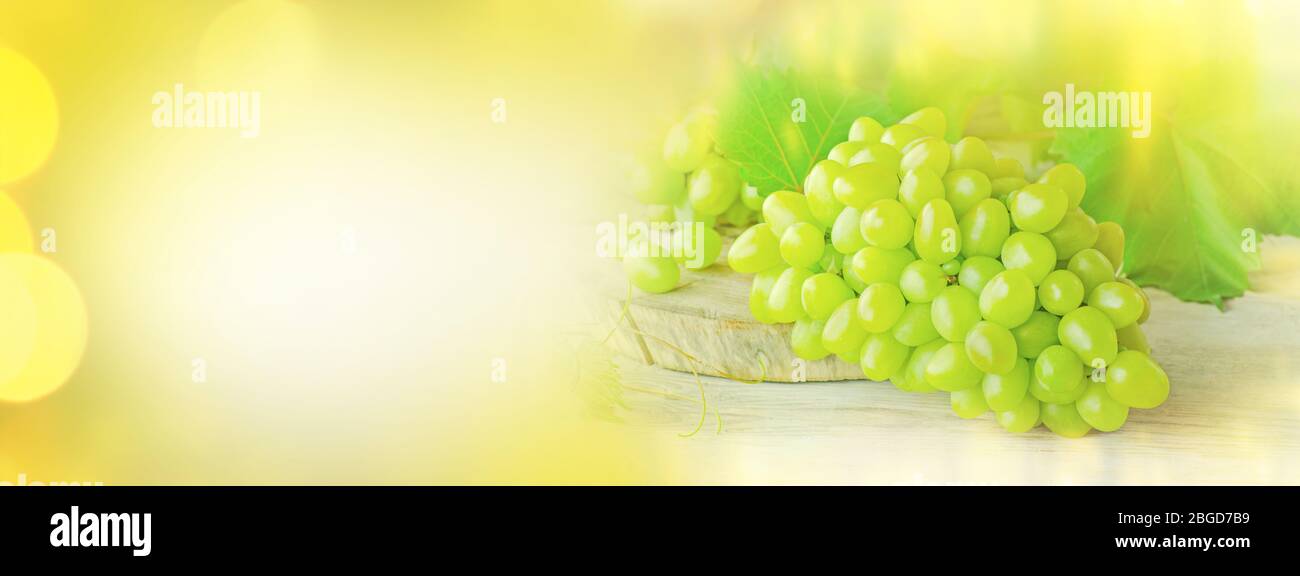 White grapes on wooden background with sun lights. Fresh green grapes ...