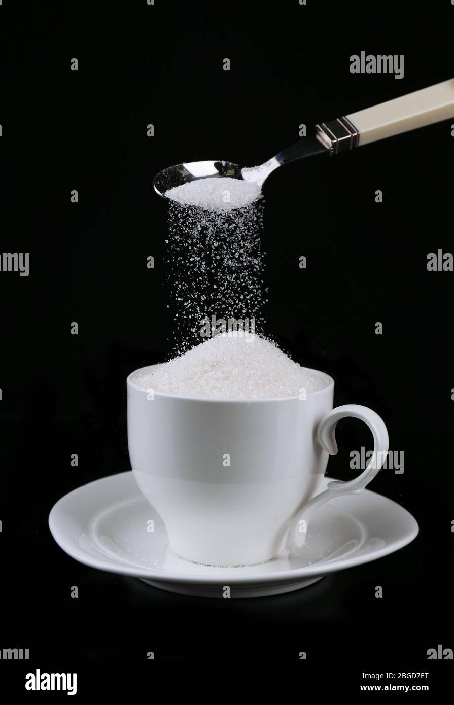 Sugar in cup isolated on black Stock Photo - Alamy