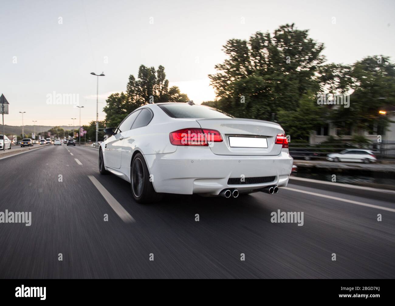 White car driving behind road hi-res stock photography and images - Alamy