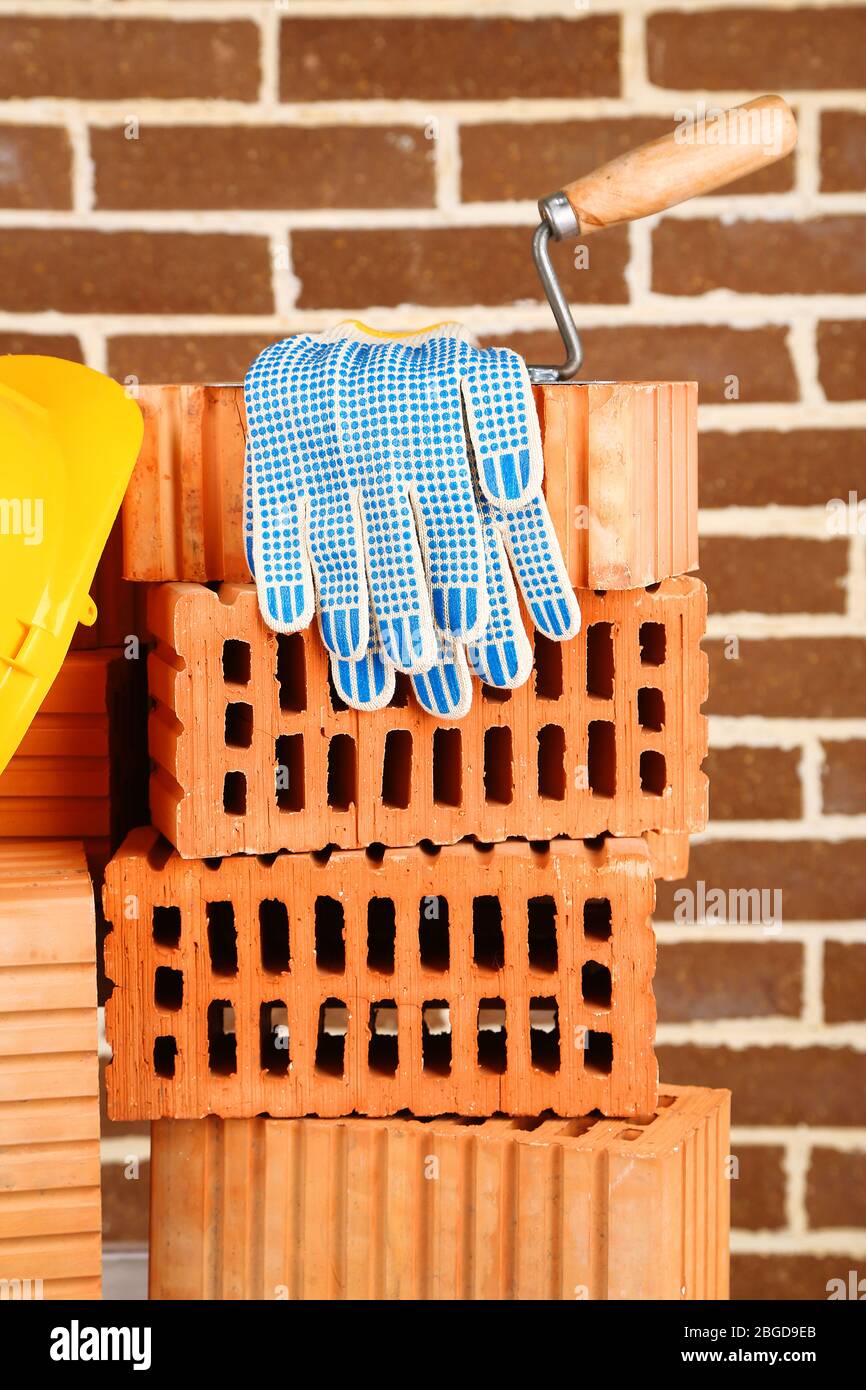 New bricks and building tools on brick wall background Stock Photo - Alamy