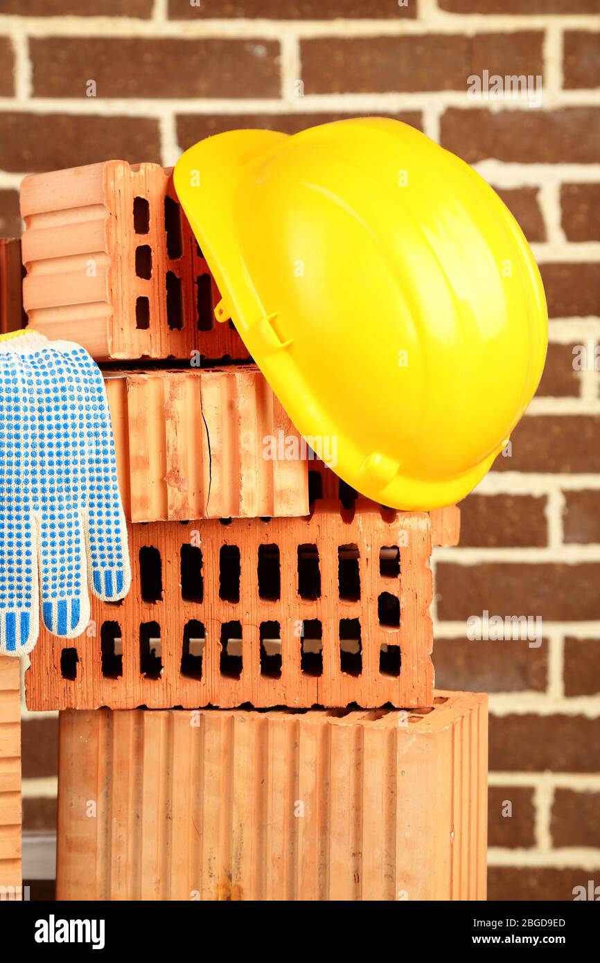New bricks and building tools on brick wall background Stock Photo - Alamy