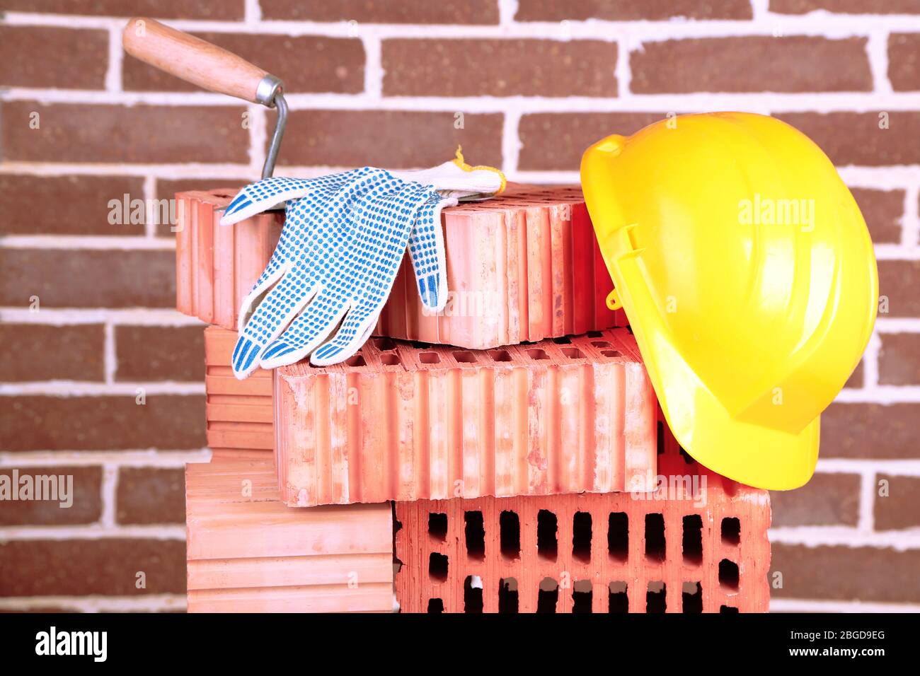 New bricks and building tools on brick wall background Stock Photo - Alamy