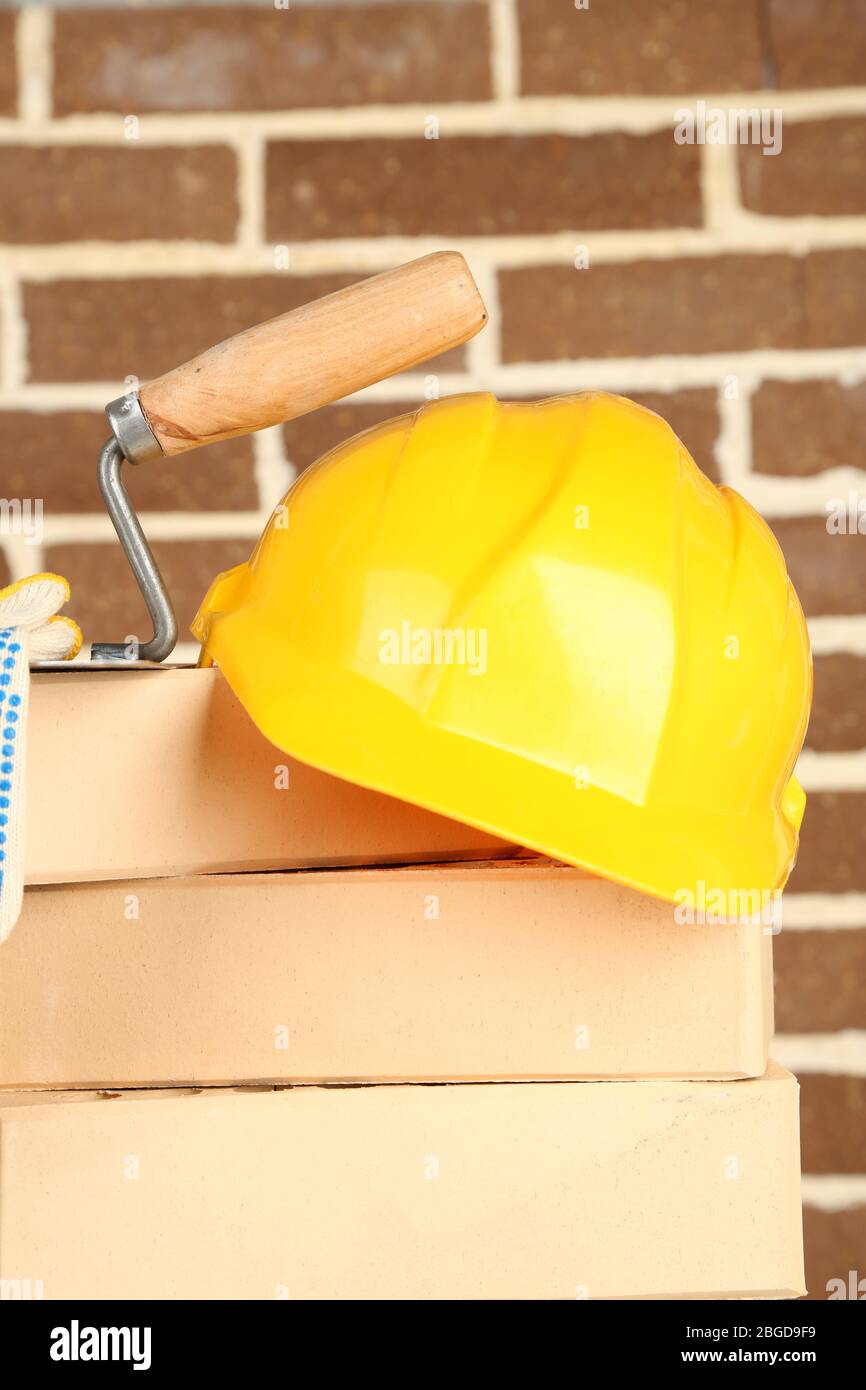 New bricks and building tools on brick wall background Stock Photo - Alamy