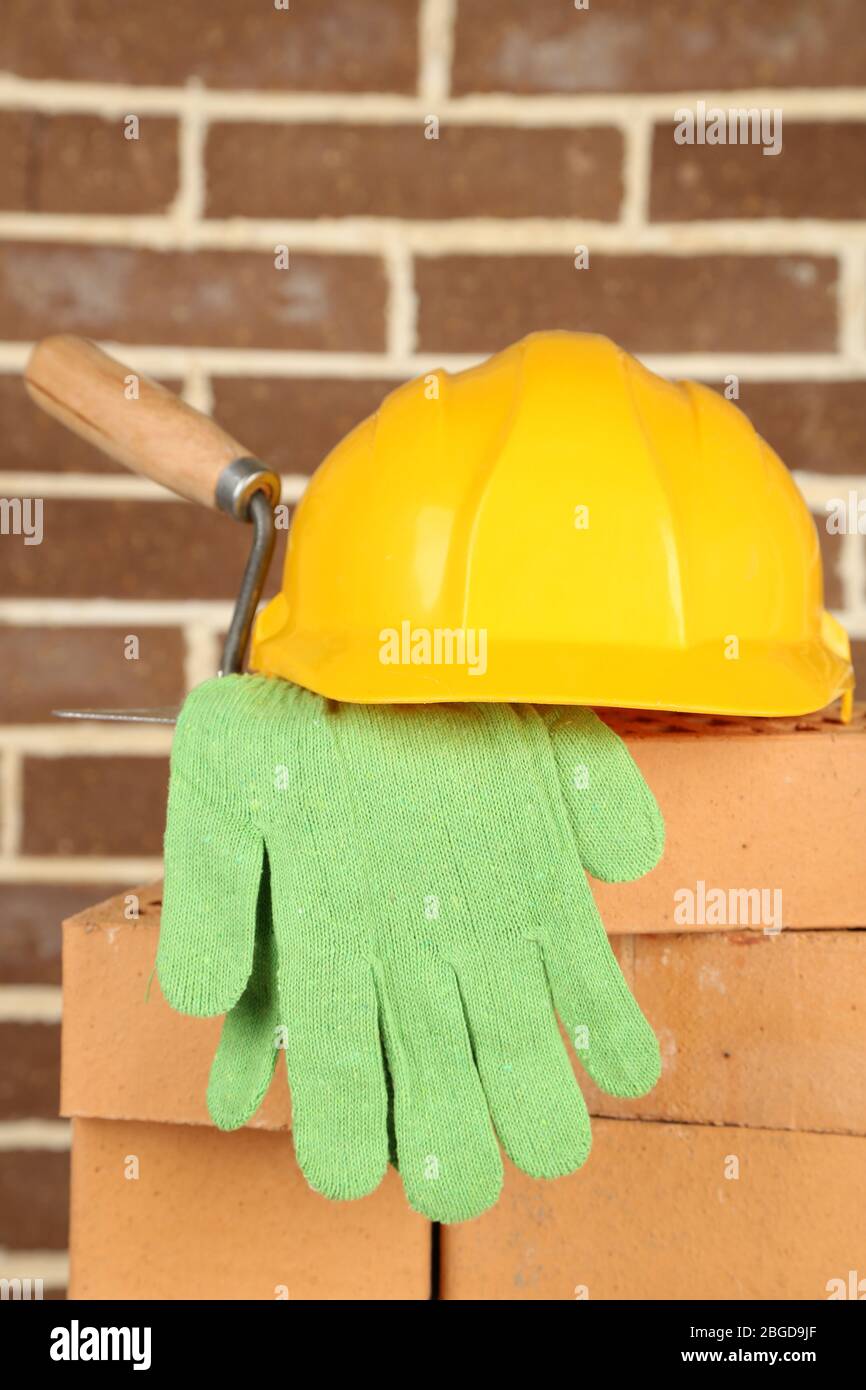 New bricks and building tools on brick wall background Stock Photo - Alamy