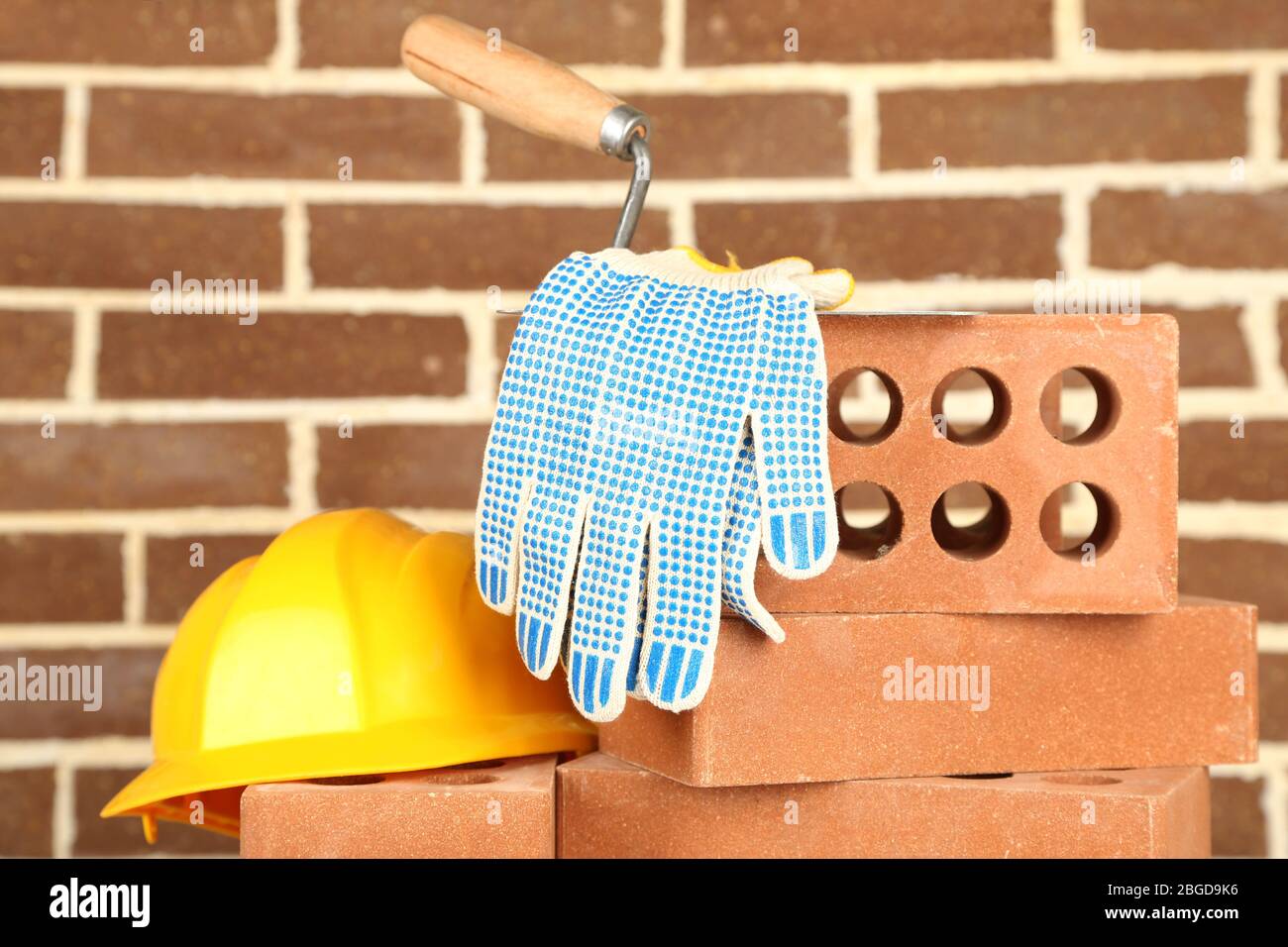 New bricks and building tools on brick wall background Stock Photo - Alamy