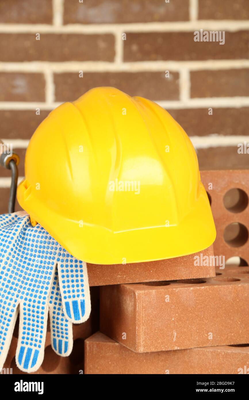 New bricks and building tools on brick wall background Stock Photo - Alamy