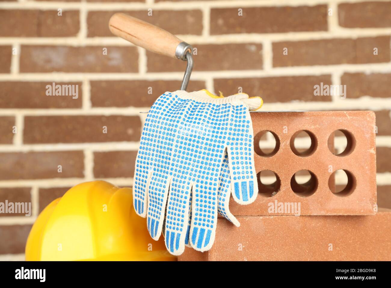 New bricks and building tools on brick wall background Stock Photo - Alamy