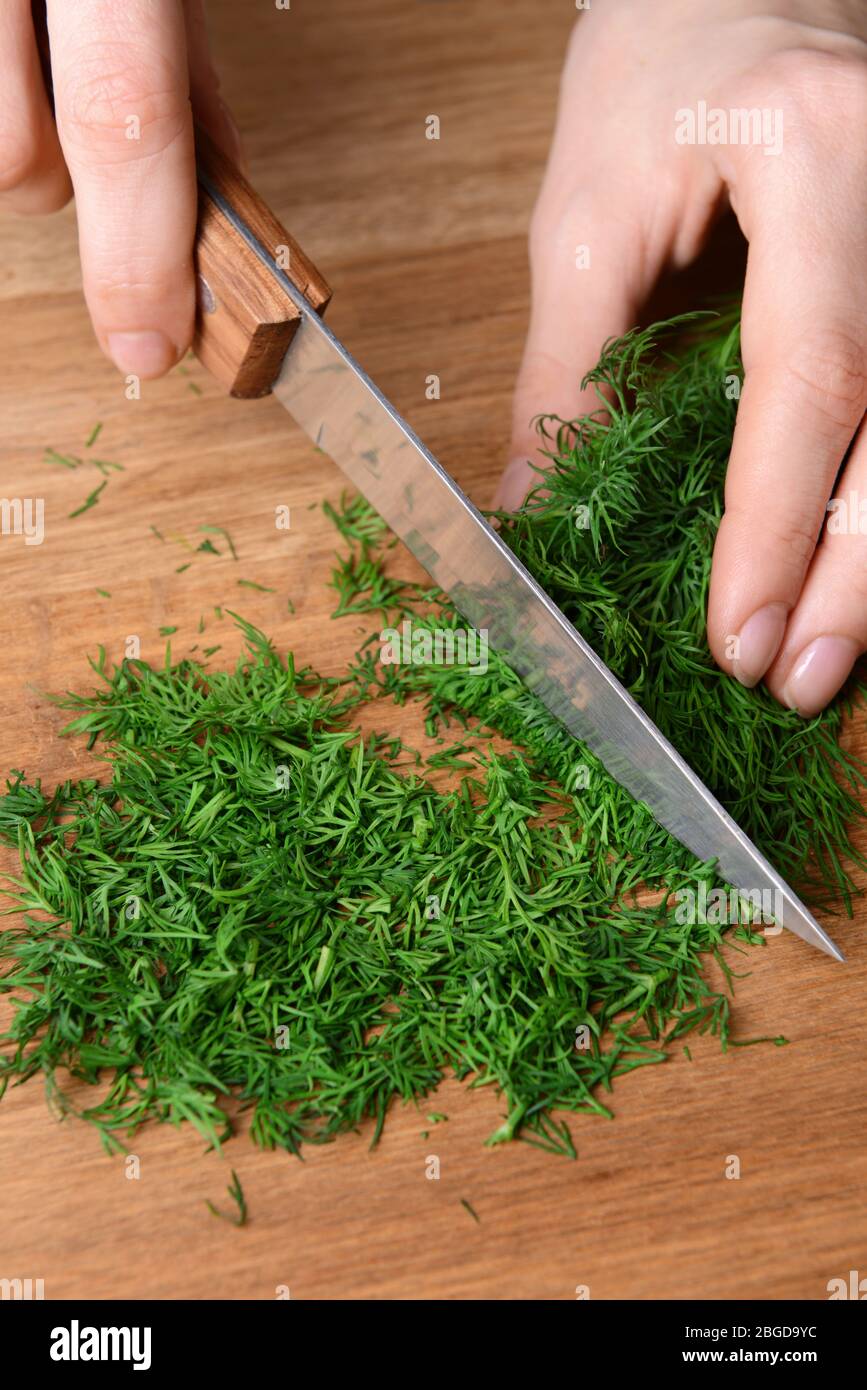 Chopped dill on wooden board close-up Stock Photo - Alamy