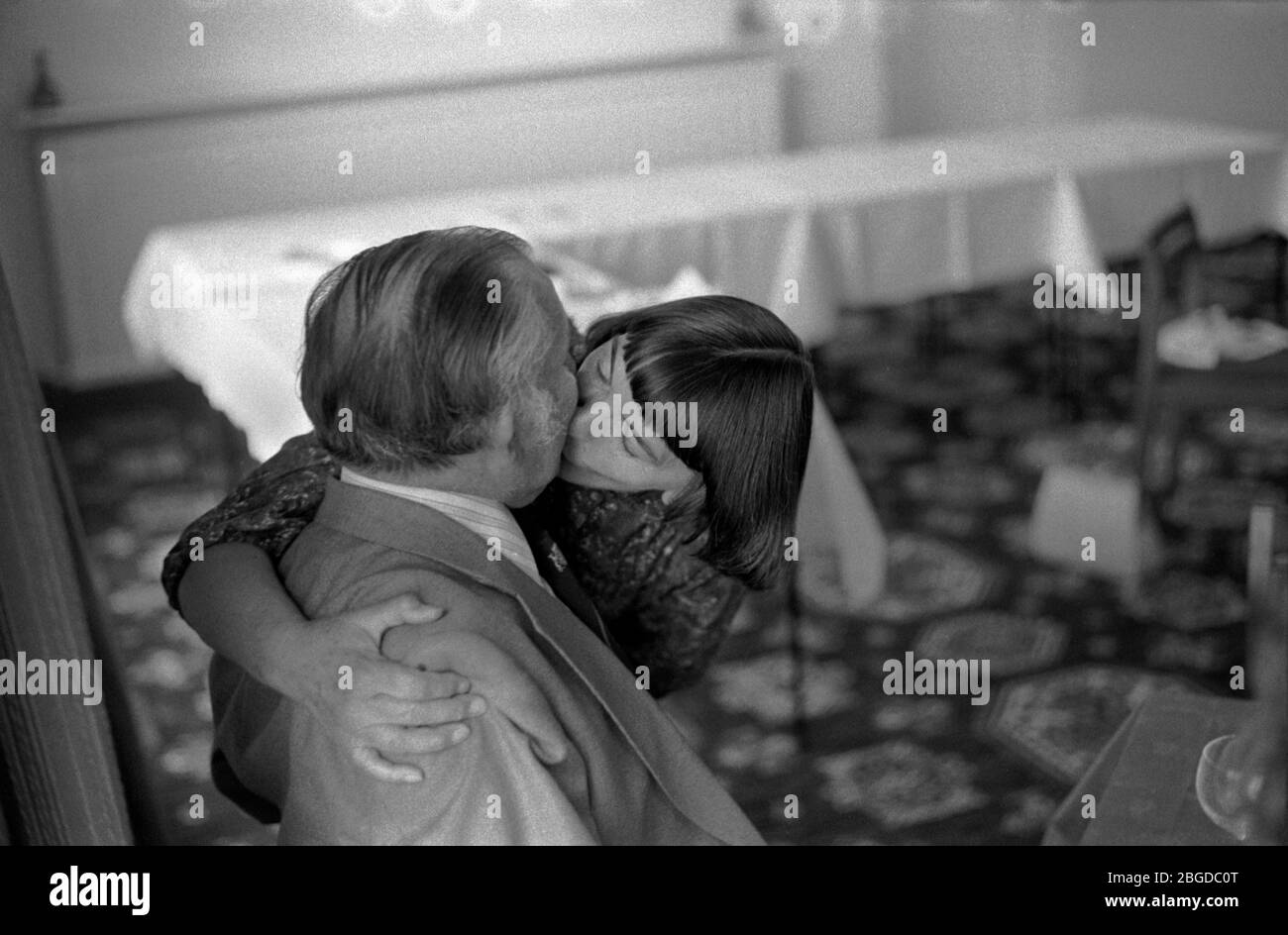 Farewell kiss, woman kissing middle aged man goodbye and giving him a ...