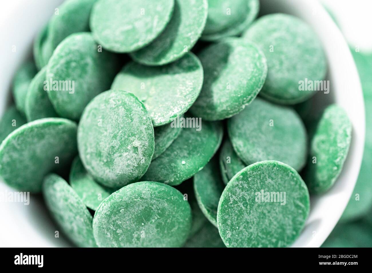 Green round chocolate chips for melting chocolate shapes on a white ...