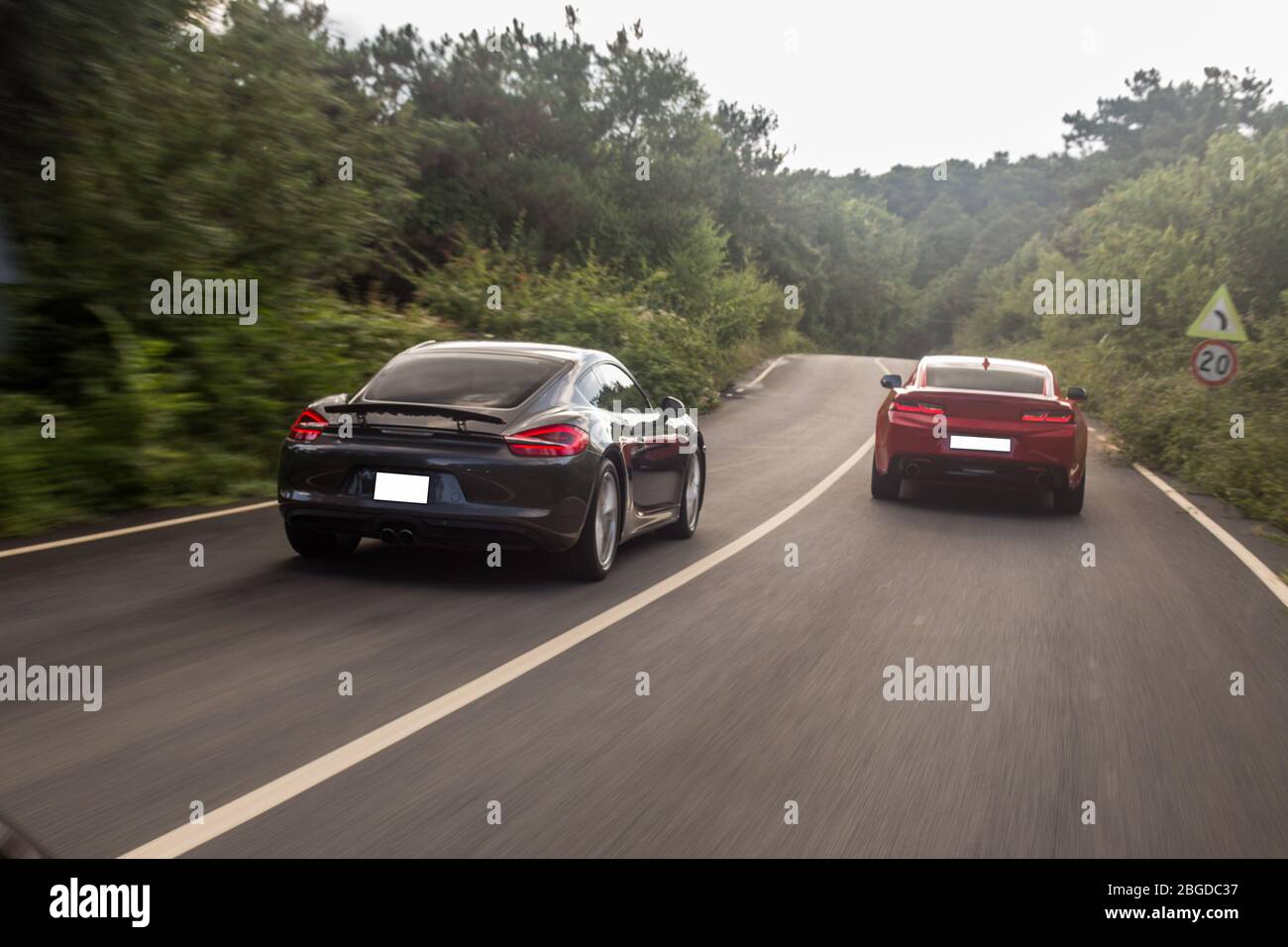 Red and black sport cars passing each other Stock Photo - Alamy