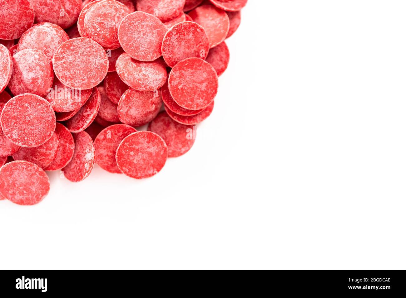 Red round chocolate chips for melting chocolate shapes on a white ...