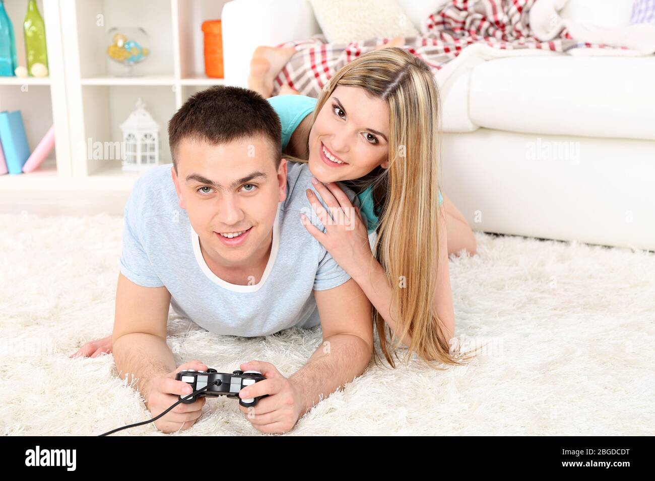 Couple playing video games on home interior background Stock Photo - Alamy