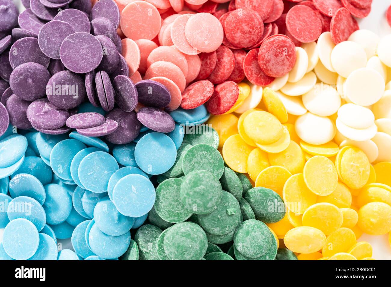 Rainbow colors of round chocolate chips for melting chocolate shapes on ...