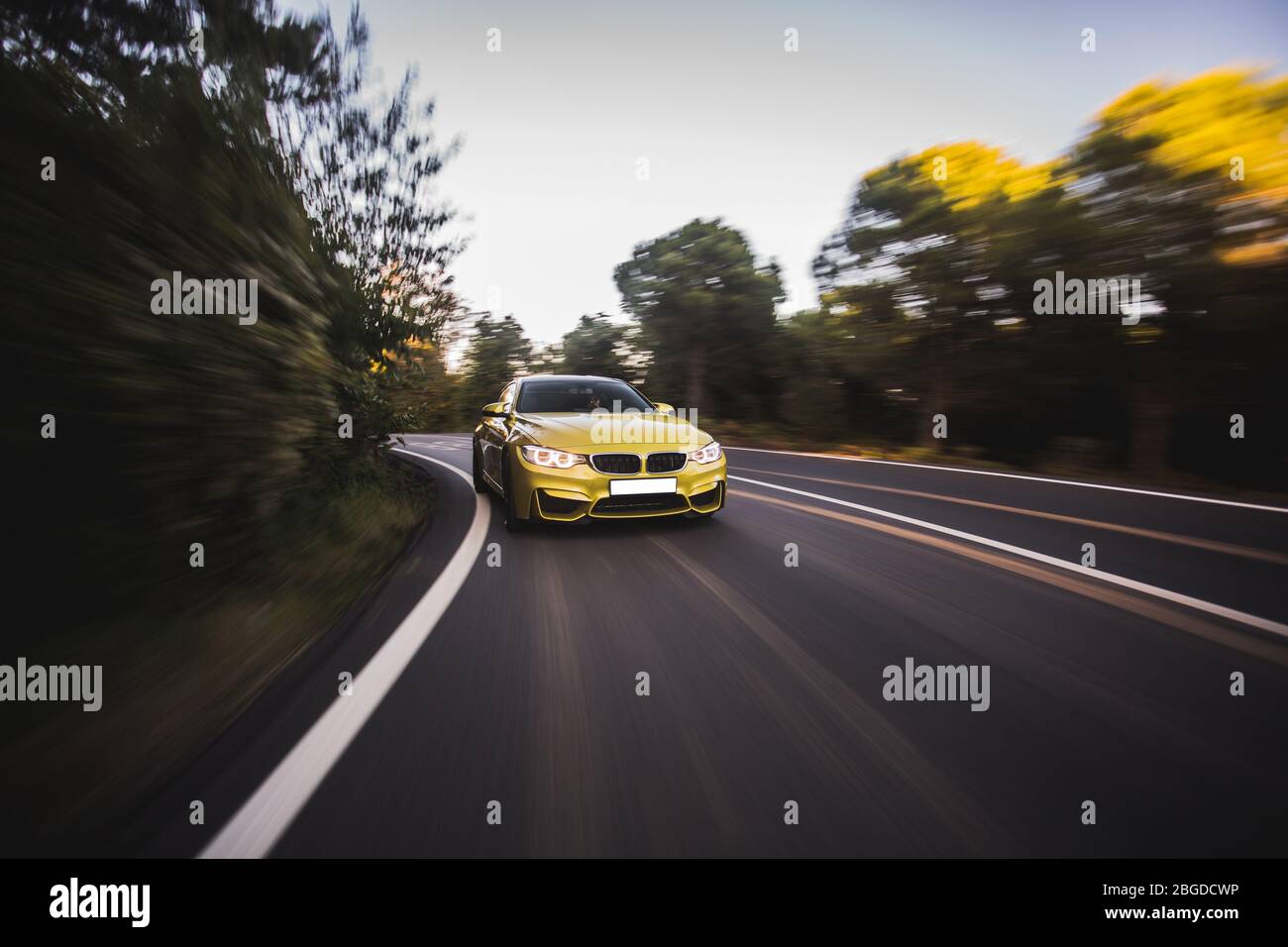 Yellow luxury sedan with black tuning on the forest highway Stock Photo ...