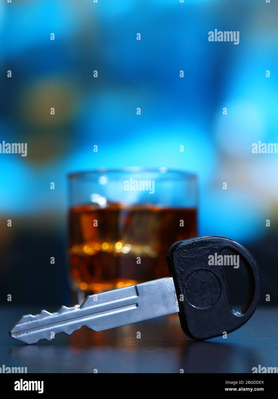 Composition with car key and glass of whiskey, on wooden table, on ...