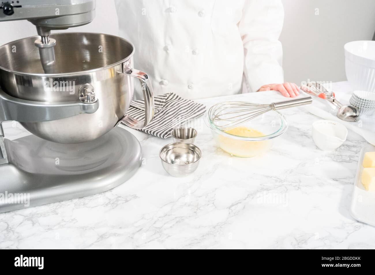 Mixing ingredients in standing kitchen mixer to bake vanilla cupcakes ...