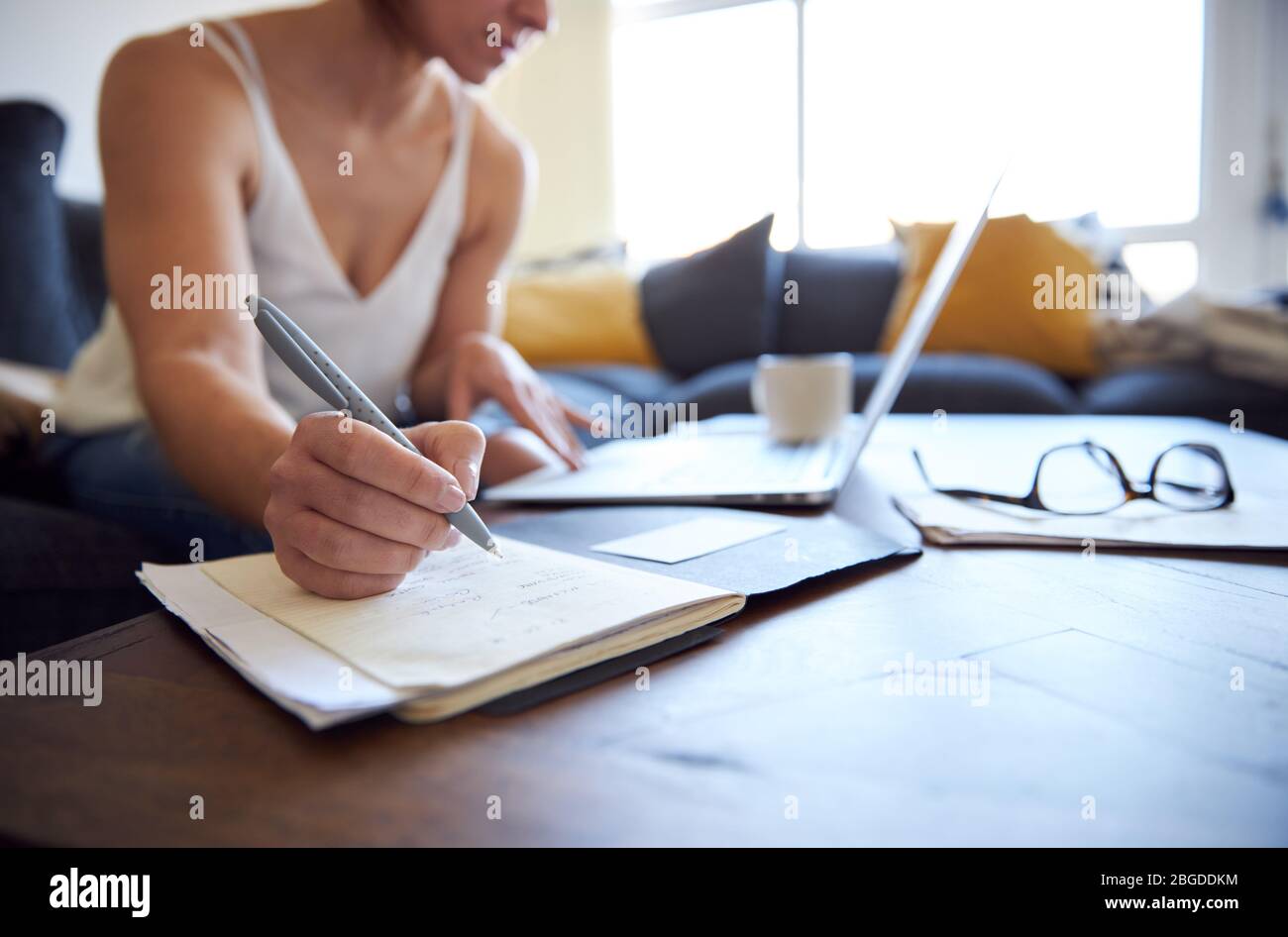 Female taking notes whilst working from home Stock Photo - Alamy