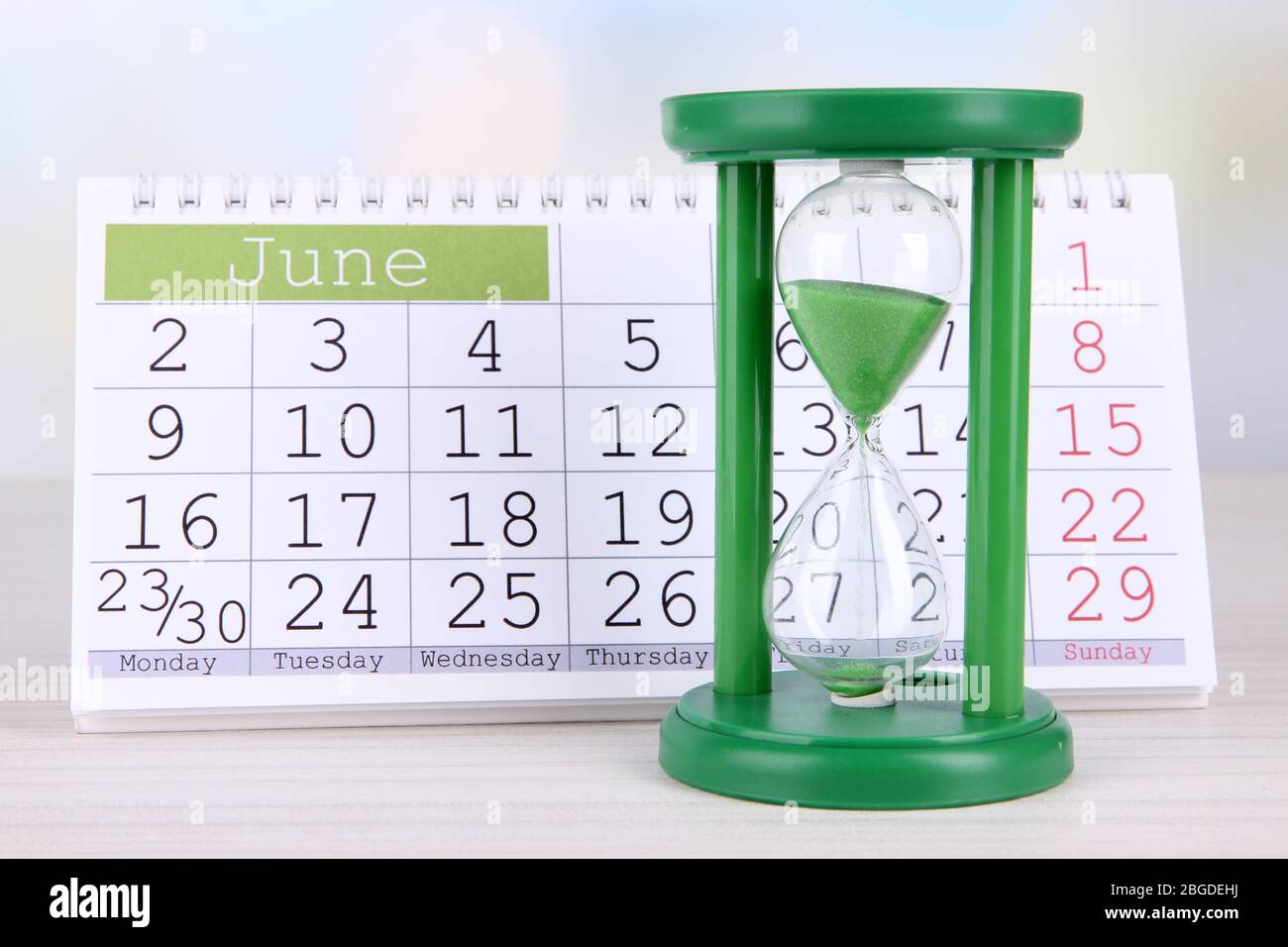 Hourglass and calendar on bright background Stock Photo - Alamy