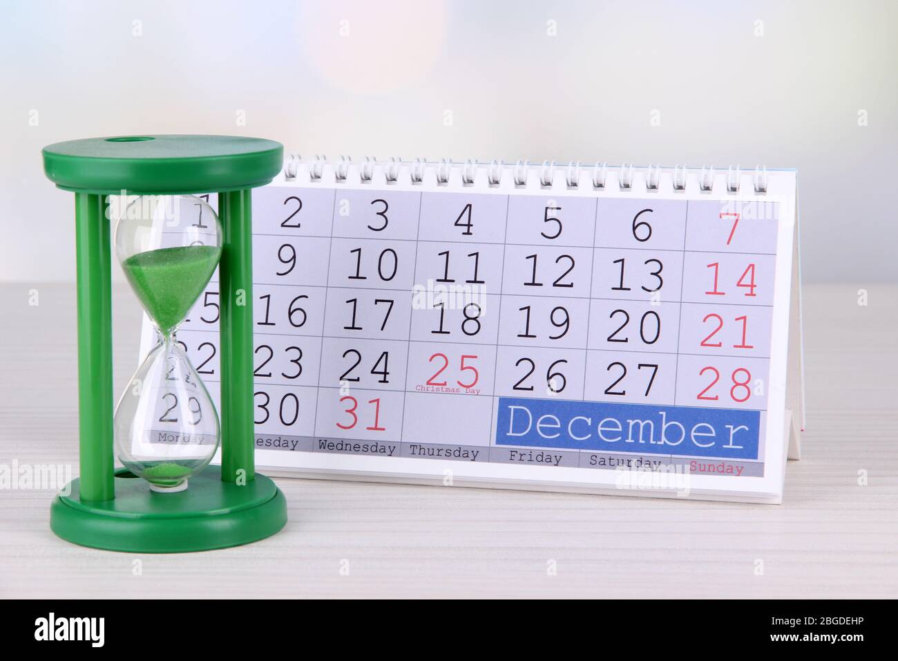 Hourglass and calendar on bright background Stock Photo - Alamy