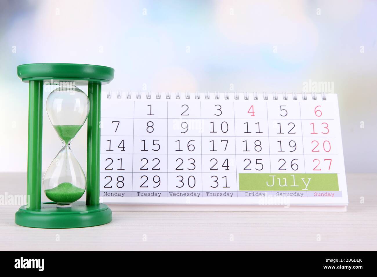 Hourglass and calendar on bright background Stock Photo - Alamy