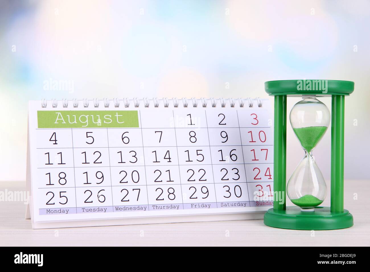 Hourglass and calendar on bright background Stock Photo - Alamy