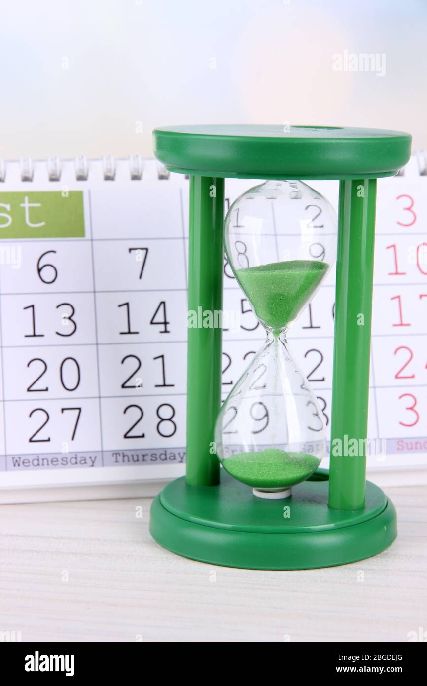 Hourglass and calendar close-up Stock Photo - Alamy