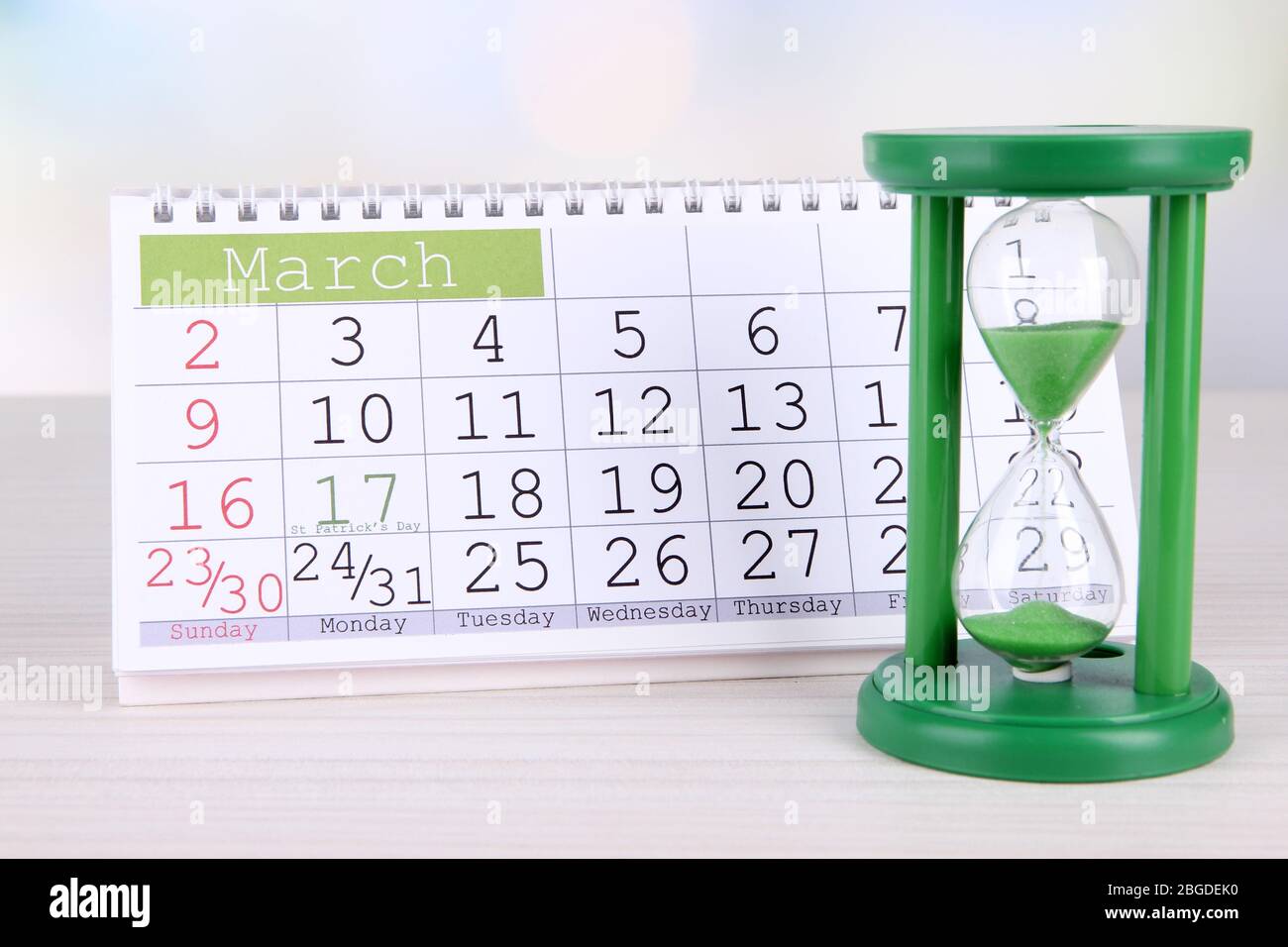 Hourglass and calendar on bright background Stock Photo - Alamy