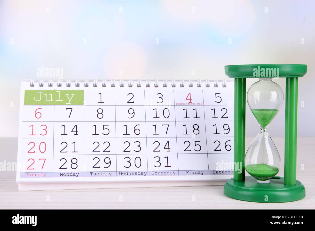 Hourglass and calendar on bright background Stock Photo - Alamy