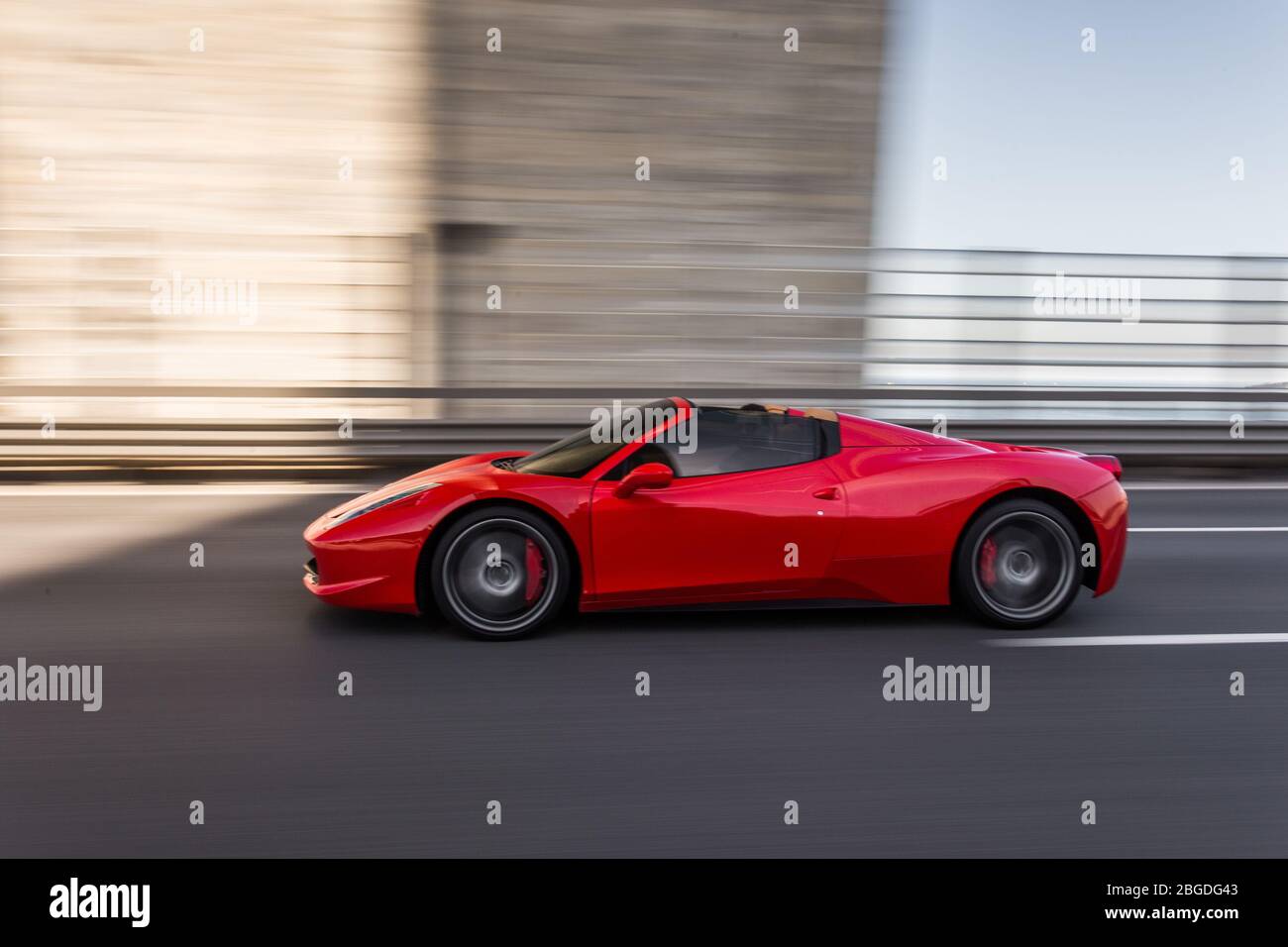 Red sport car driving on the freeway under the bridge Stock Photo - Alamy