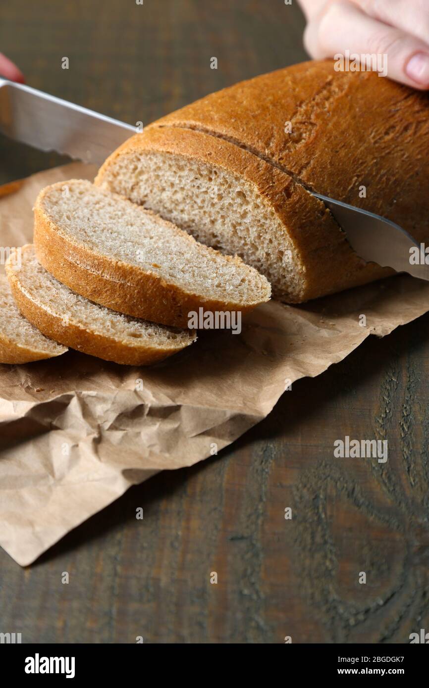 Female hands cutting bread on wooden board, close-up Stock Photo - Alamy