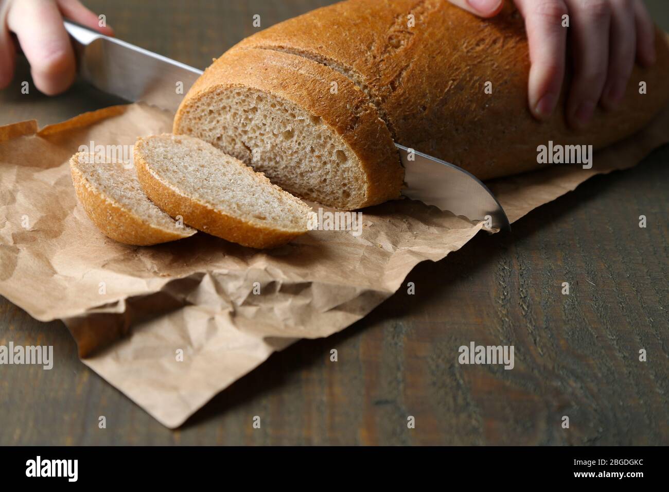 Female hands cutting bread on wooden board, close-up Stock Photo - Alamy