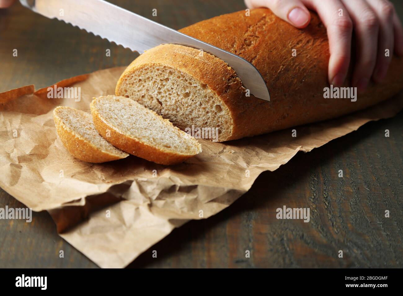 Female hands cutting bread on wooden board, close-up Stock Photo - Alamy