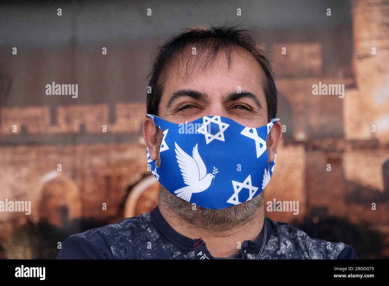 An Israeli man wearing a face mask decorated with the Jewish Star of ...