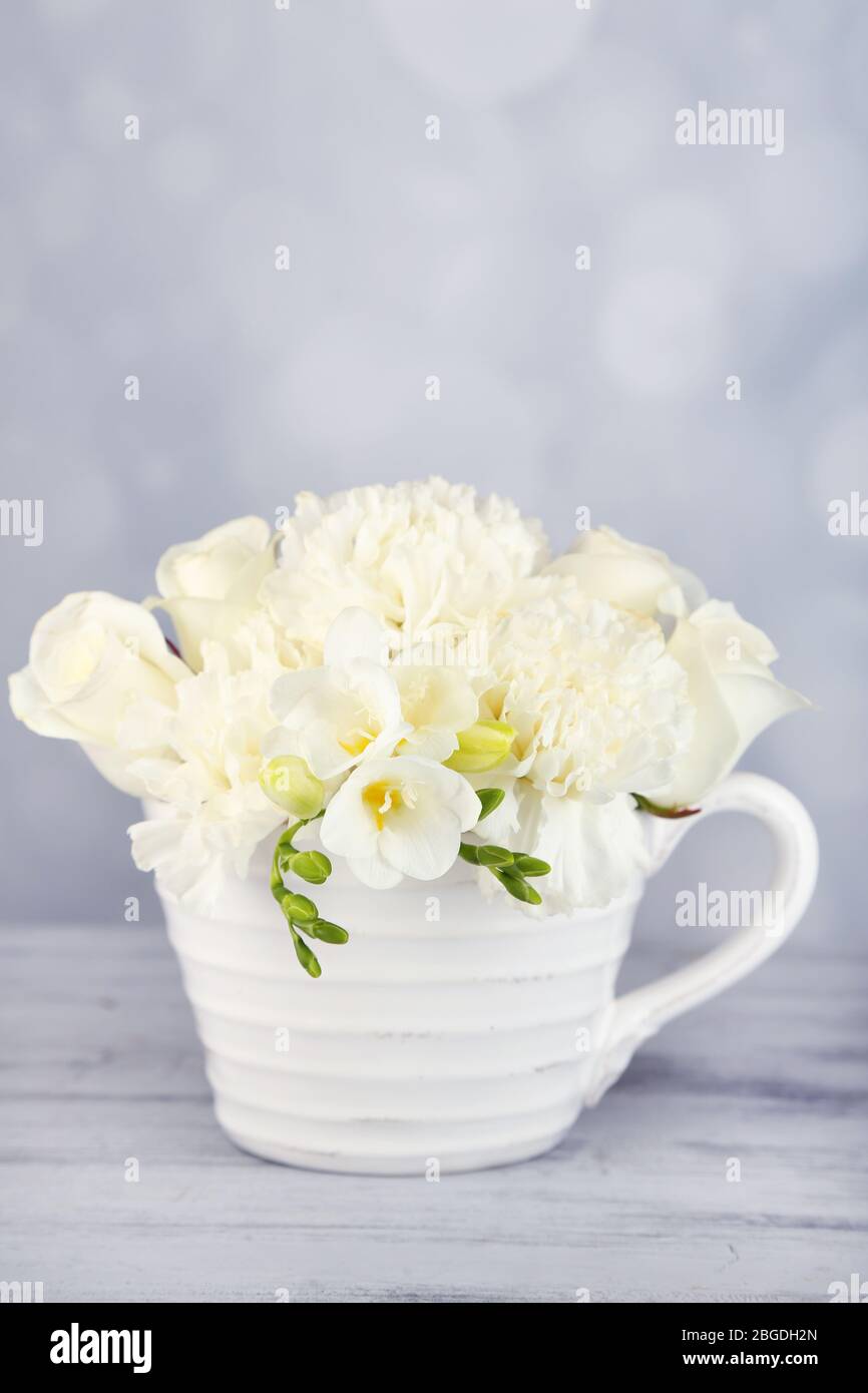 Beautiful spring flowers in cup on light background Stock Photo - Alamy