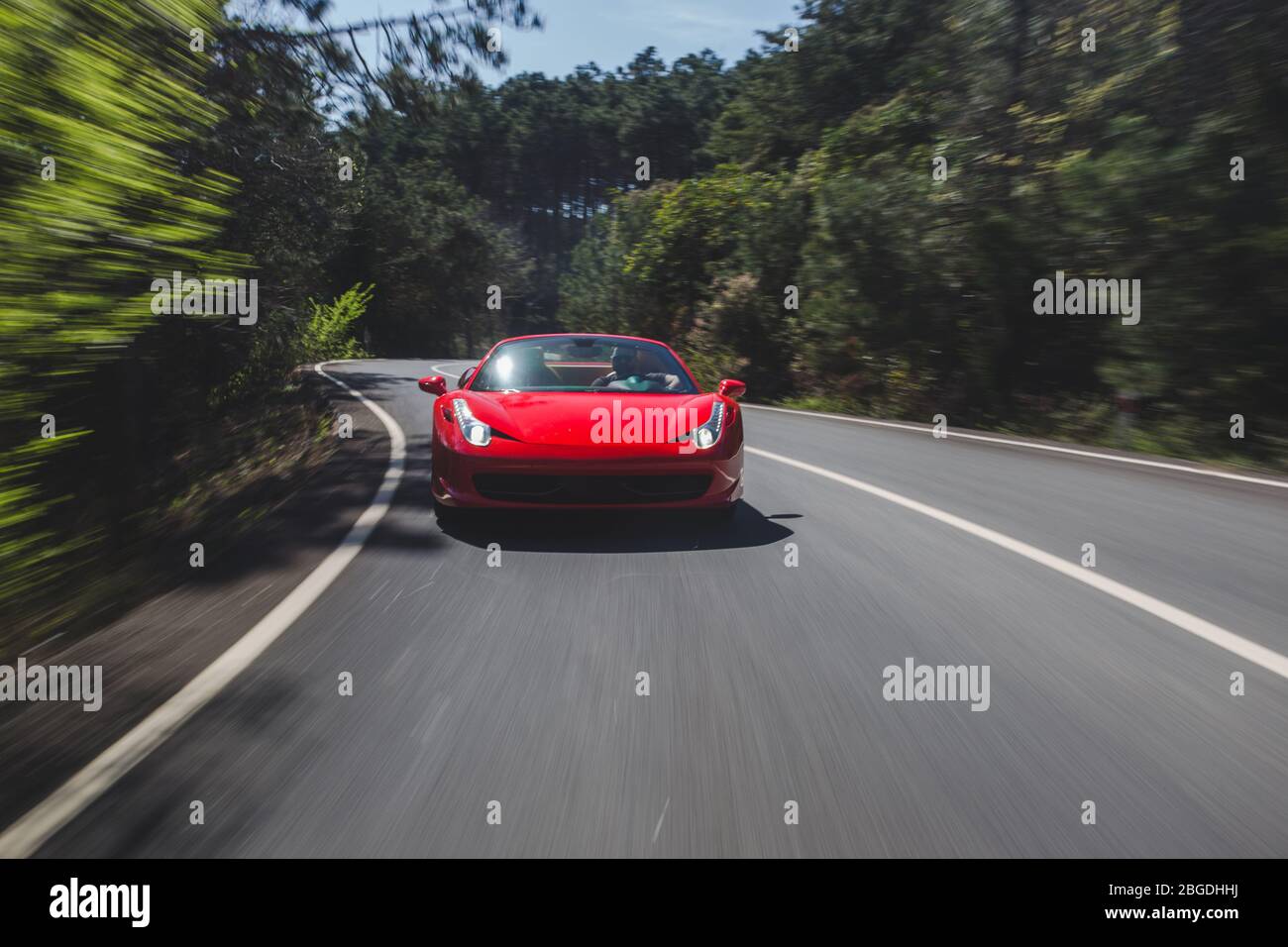 Red sport car driving on the freeway,front lights on Stock Photo - Alamy