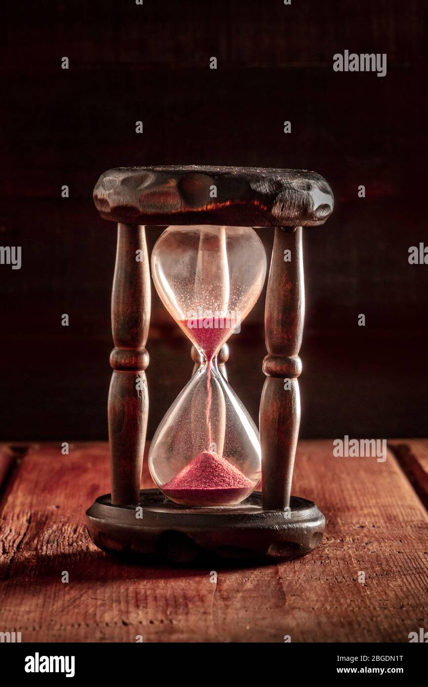 Time is running out concept. An hourglass with sand falling through, on ...