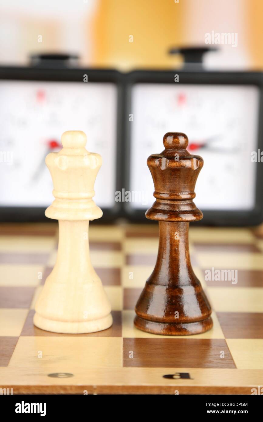 Chessboard with chess and clock on light background Stock Photo - Alamy