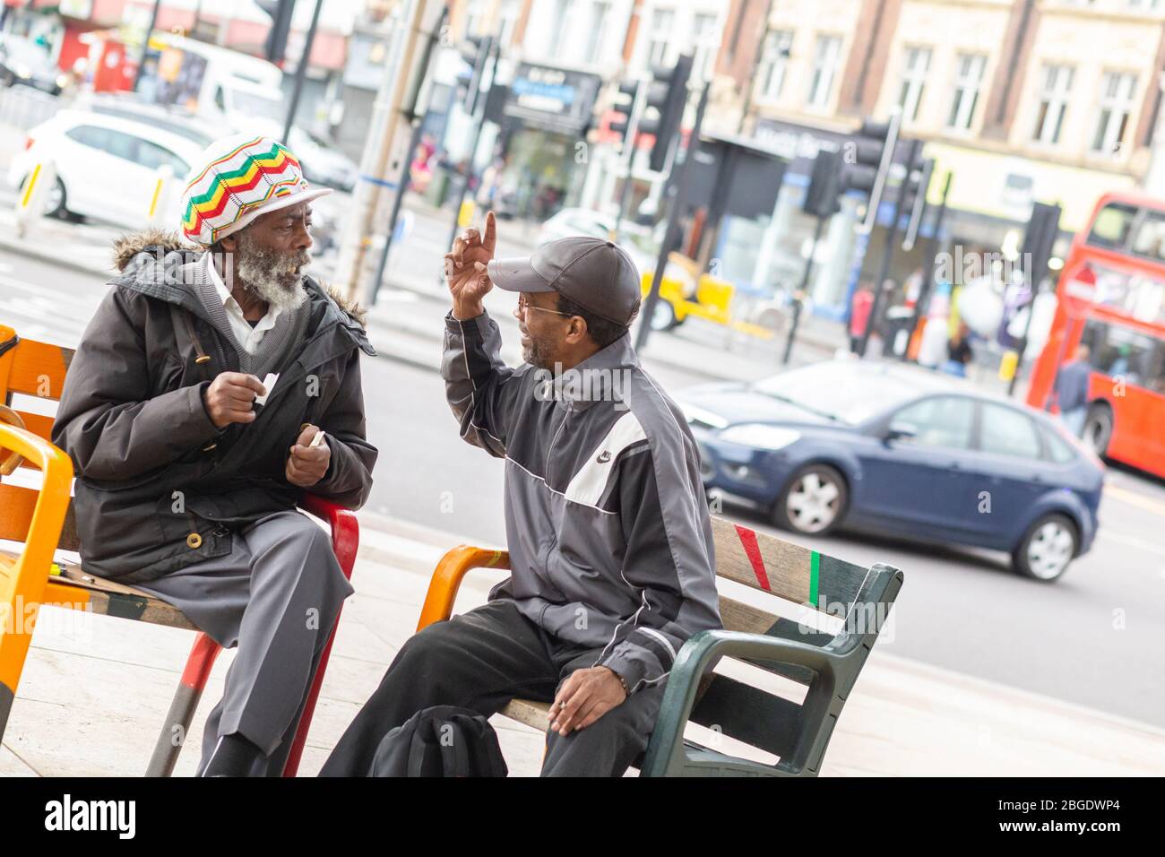 Two men conversing on seats in Windrush Square, Brixton, London Stock ...