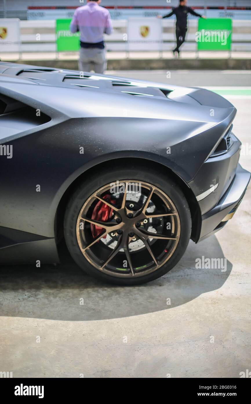 Grey racing car in the rally stadium on the track, back wheels view ...