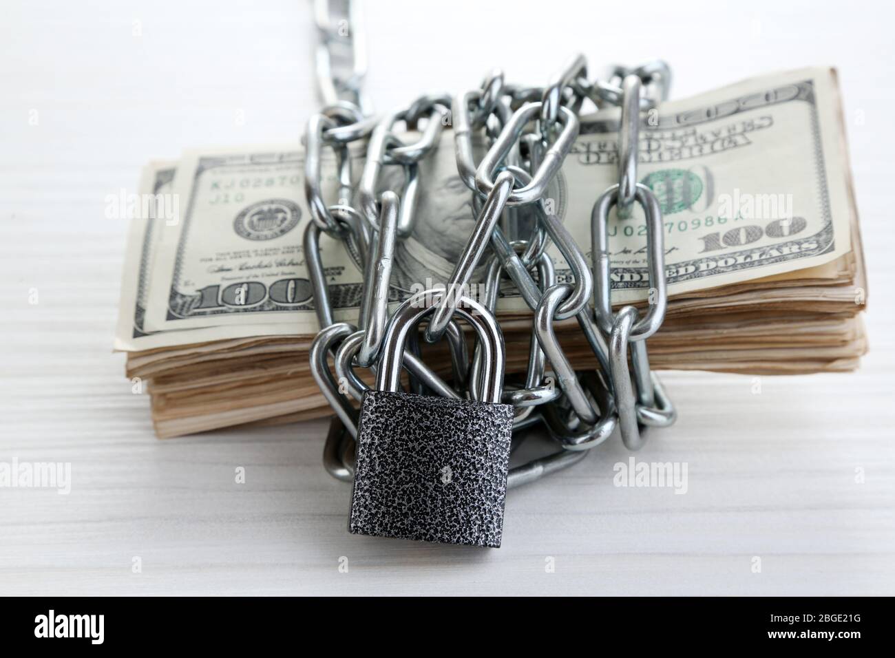Dollars currency with lock and chain on wooden table Stock Photo - Alamy
