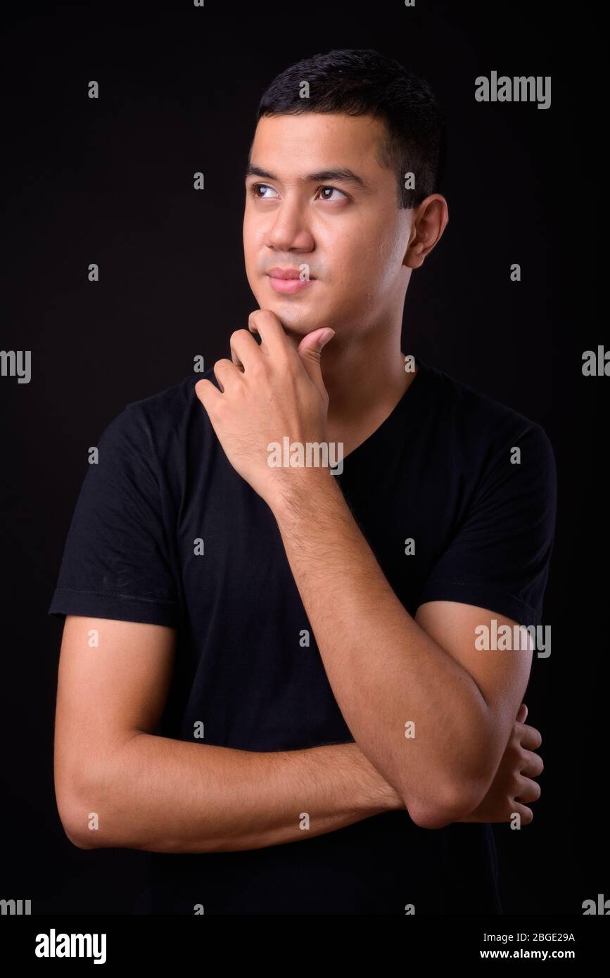 Portrait of young handsome Asian man thinking Stock Photo - Alamy