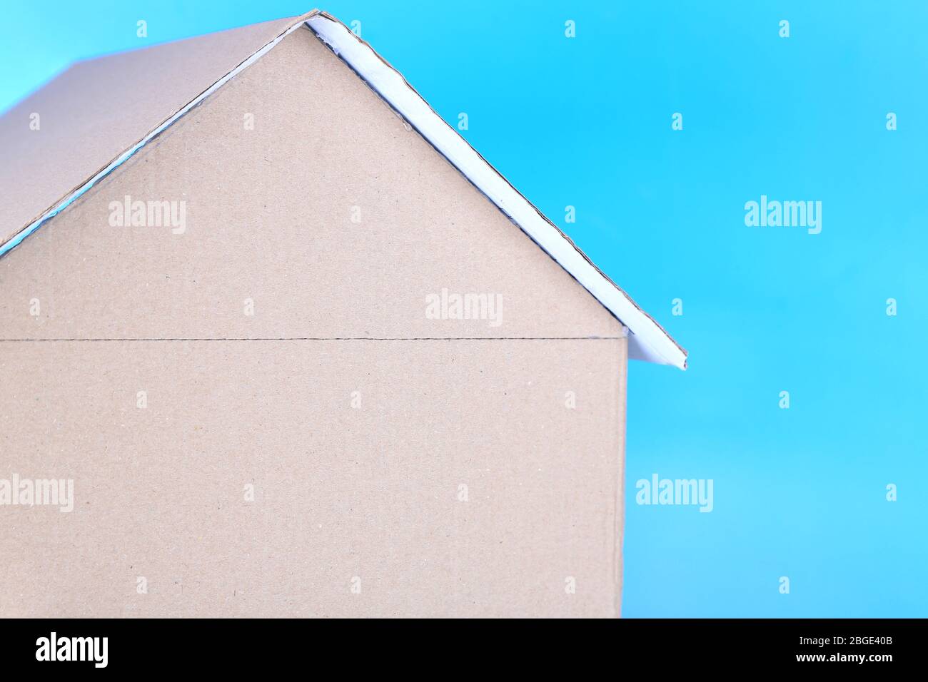 Cardboard house on bright background Stock Photo - Alamy