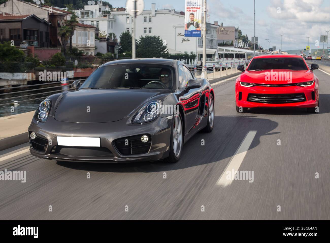 Red and black supercars racing on the city streets in a summer day ...