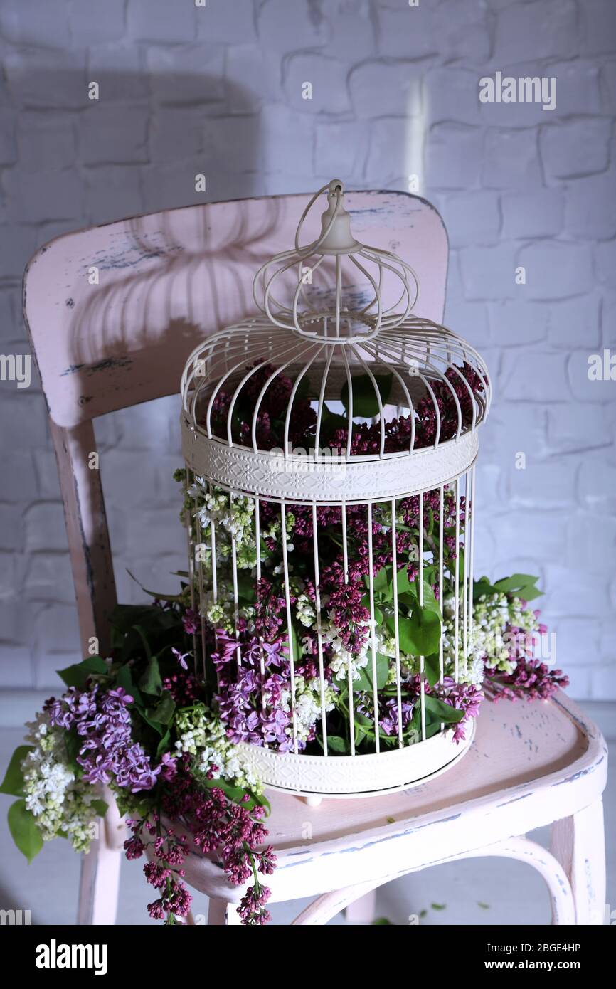 Beautiful lilac flowers in decorative cell, on chair, on light ...