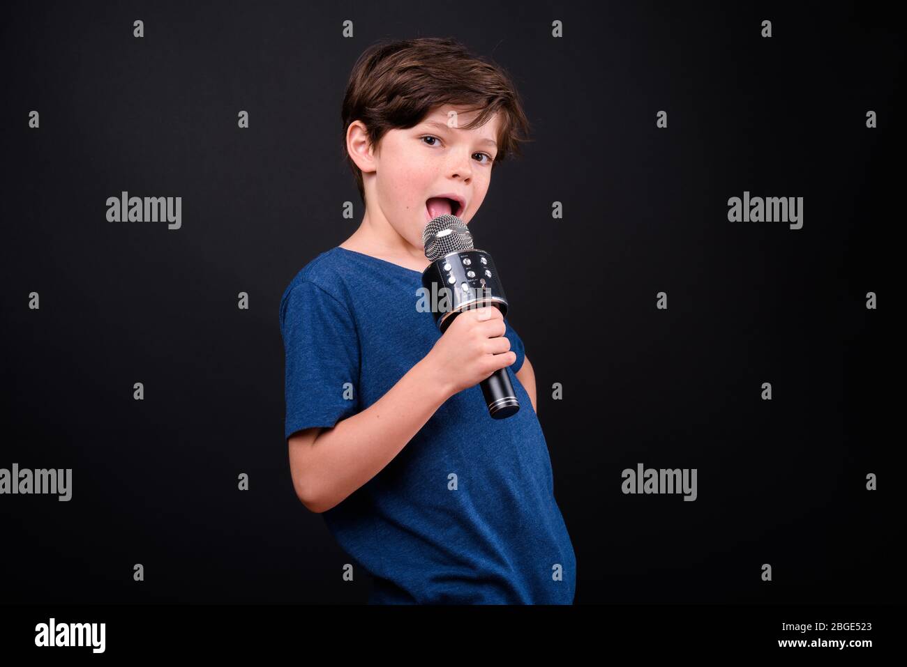 Portrait of young handsome boy singing with microphone Stock Photo - Alamy