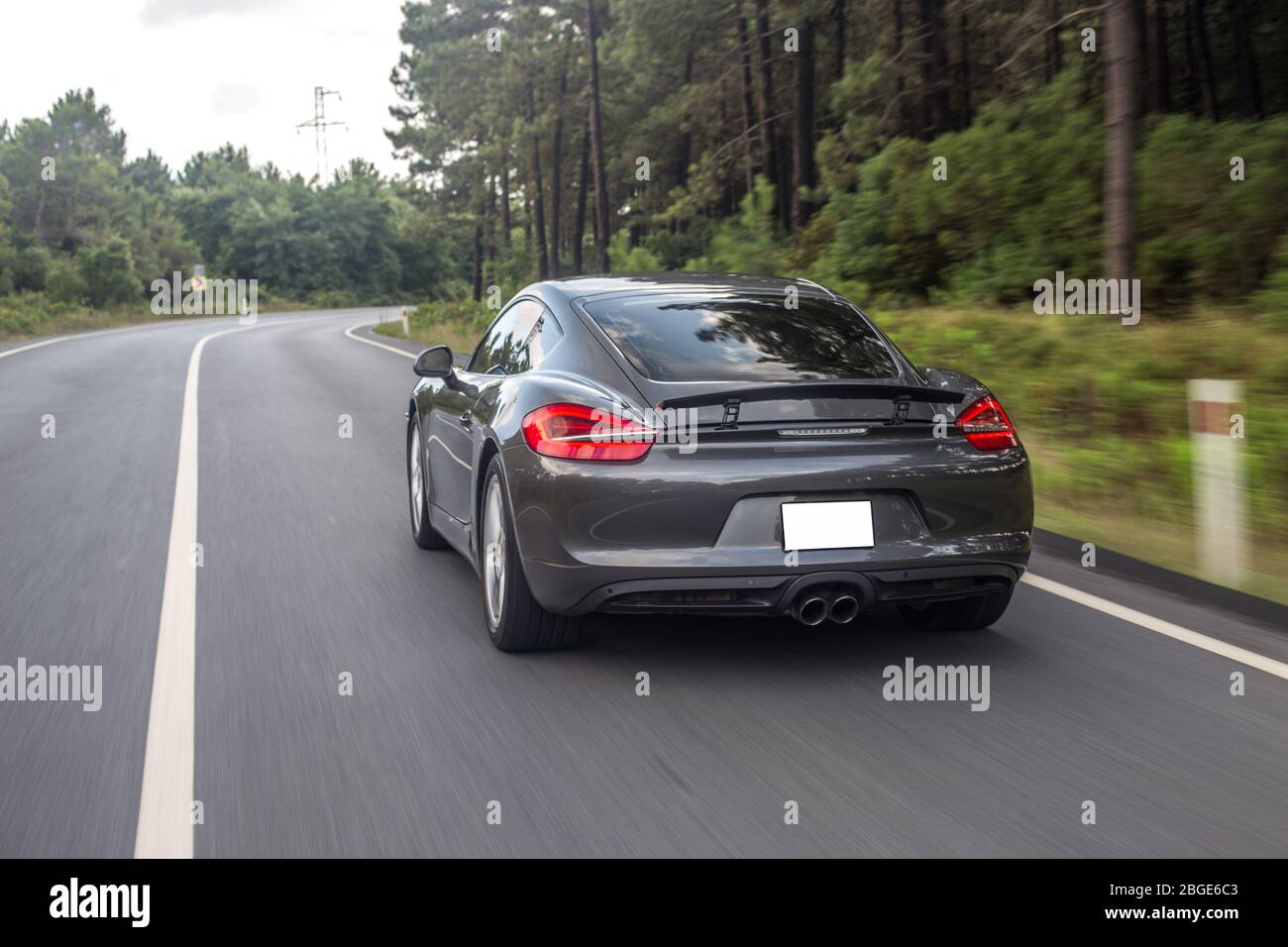 Grey color supercar motion in the landscapes through forest Stock Photo ...