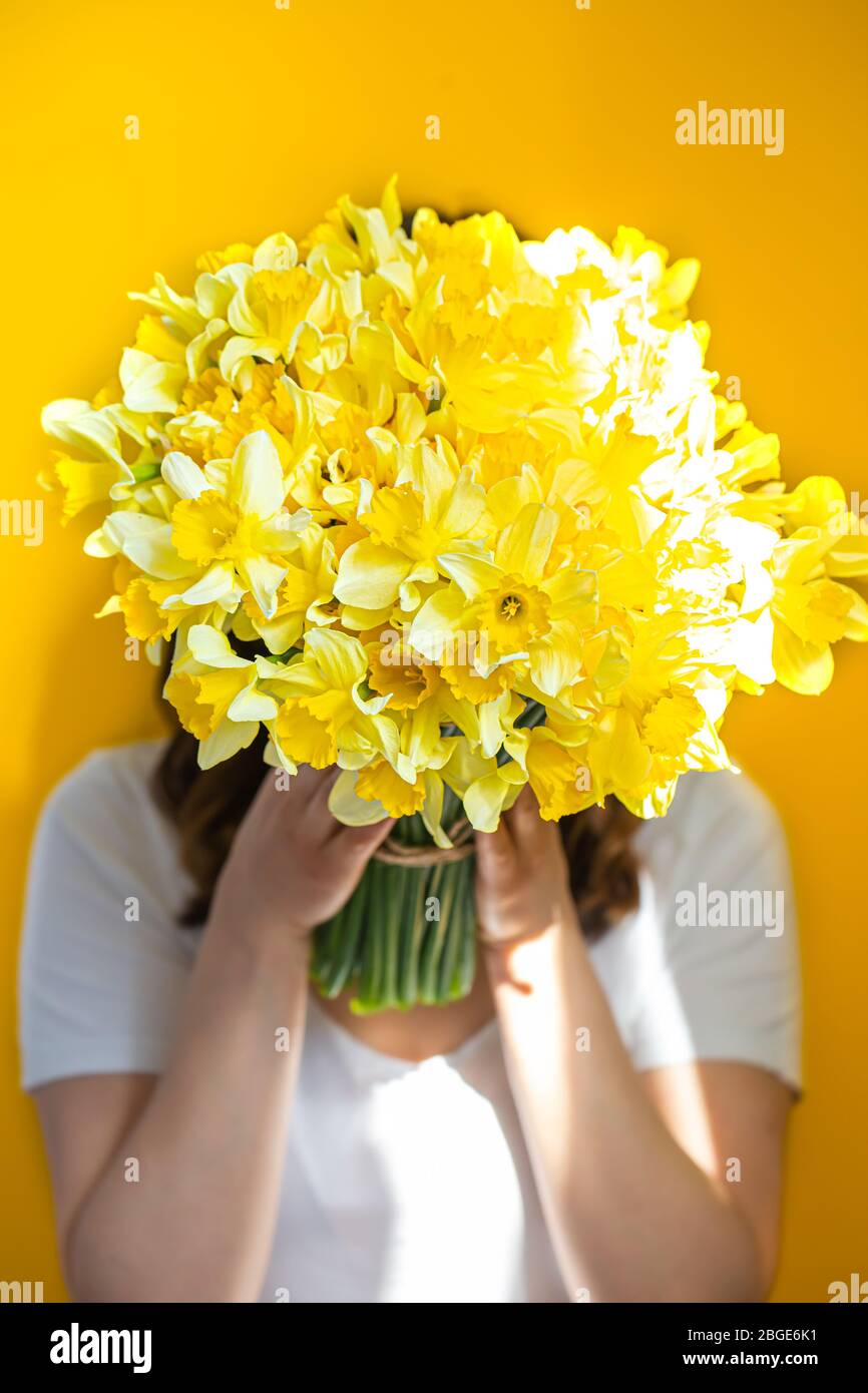 A young woman covers her face with a bouquet of flowers Stock Photo - Alamy