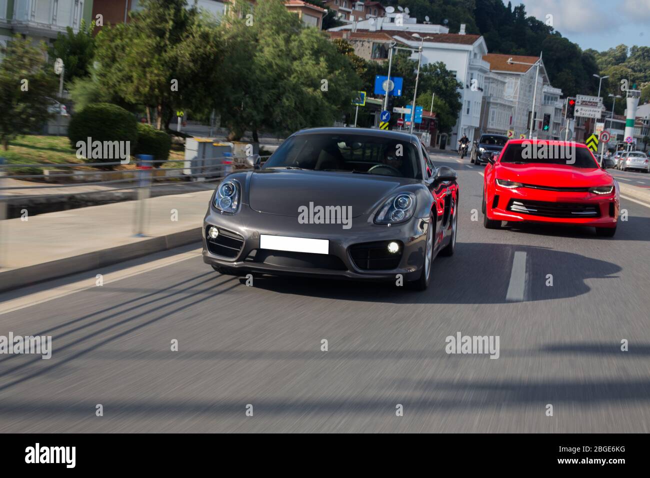 Red and black supercars racing on the city streets across properties ...