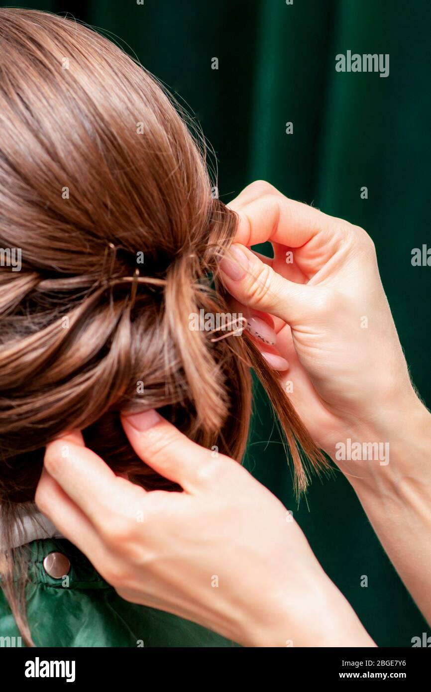 Hairdresser hands are making hairstyle for woman, back view Stock Photo ...